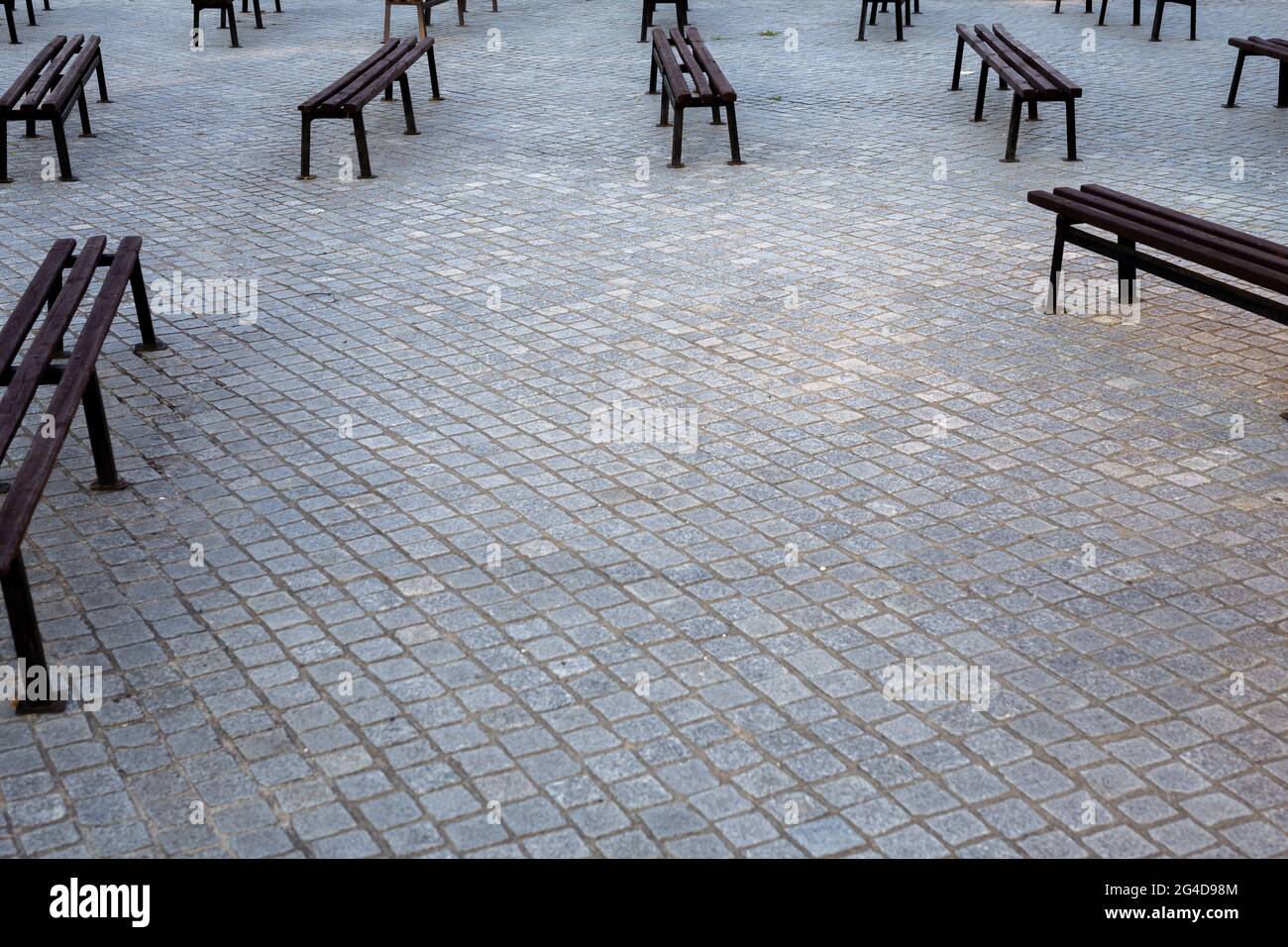 Lots of benches in a square paved with granite. Photo taken in natural ...