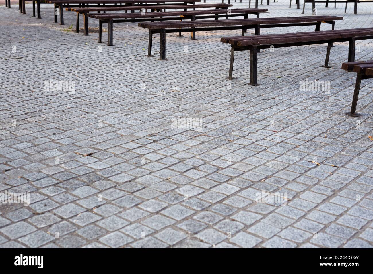Lots of benches in a square paved with granite. Photo taken in natural ...