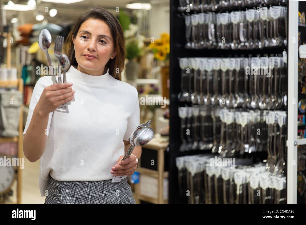 Woman chooses flatware in the shop Stock Photo - Alamy
