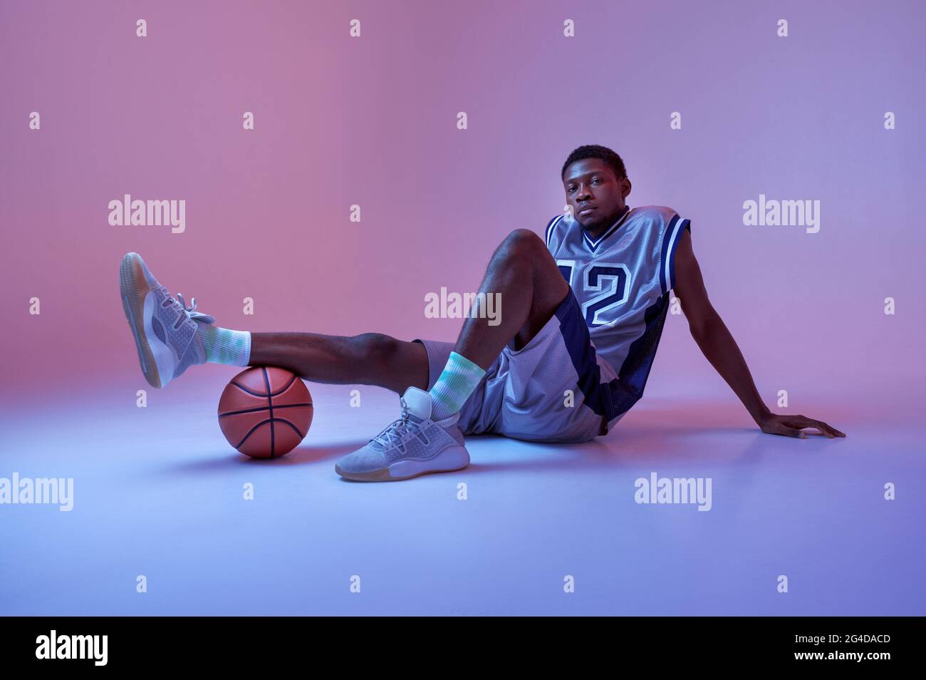 Basketball player poses with ball in studio Stock Photo - Alamy