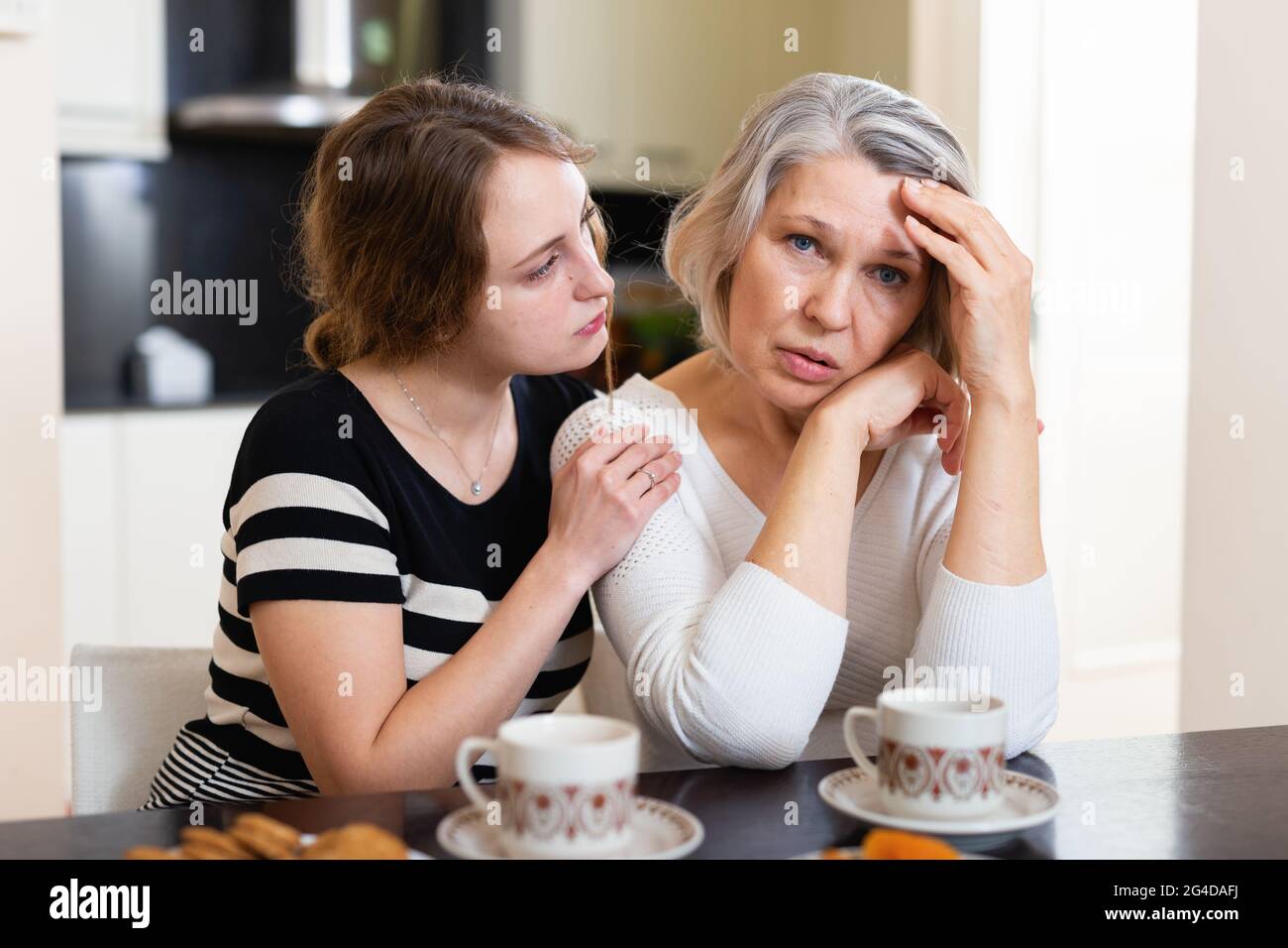 Daughter comforting upset mother Stock Photo - Alamy