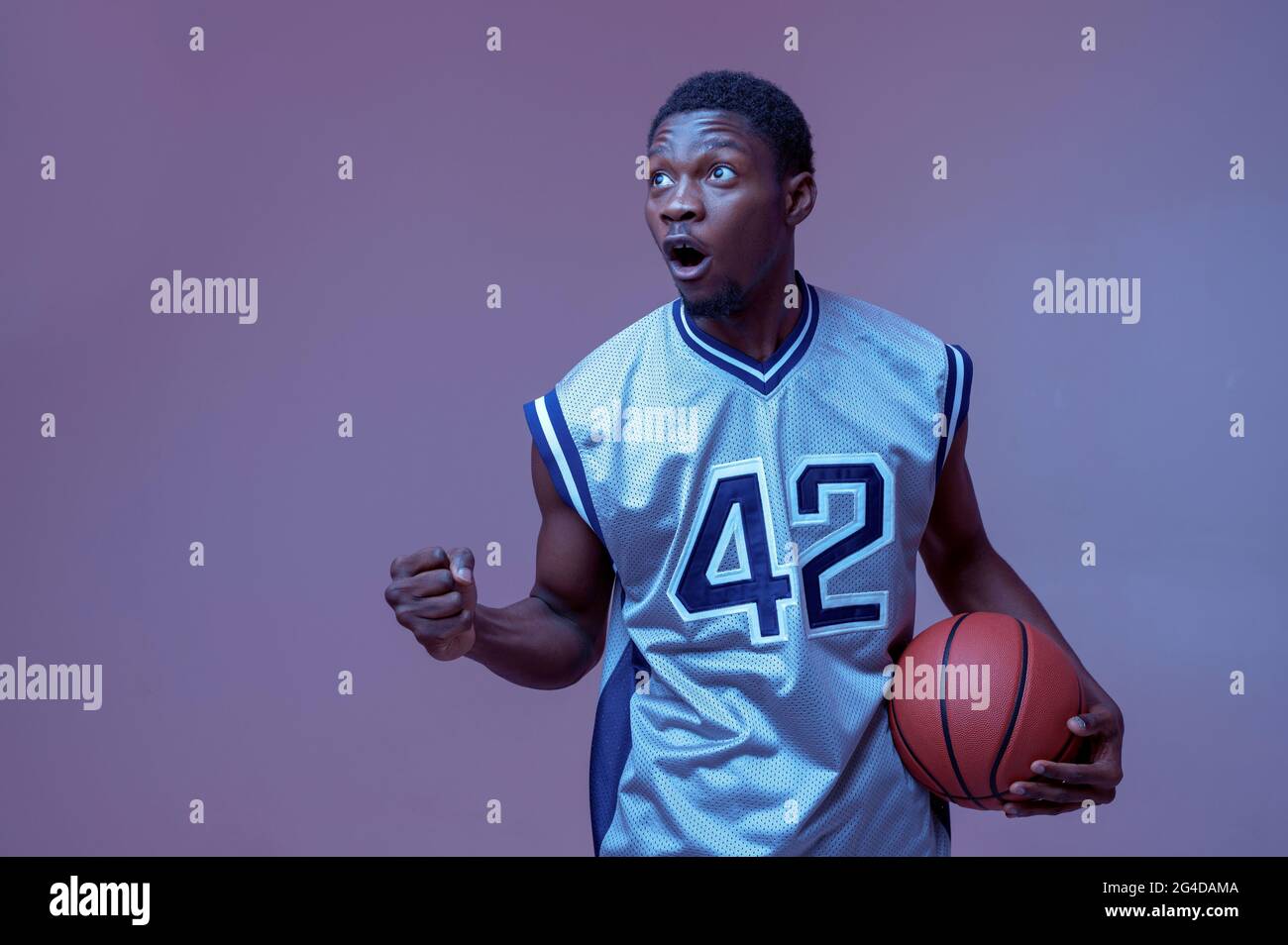 Confident basketball player poses with ball Stock Photo - Alamy