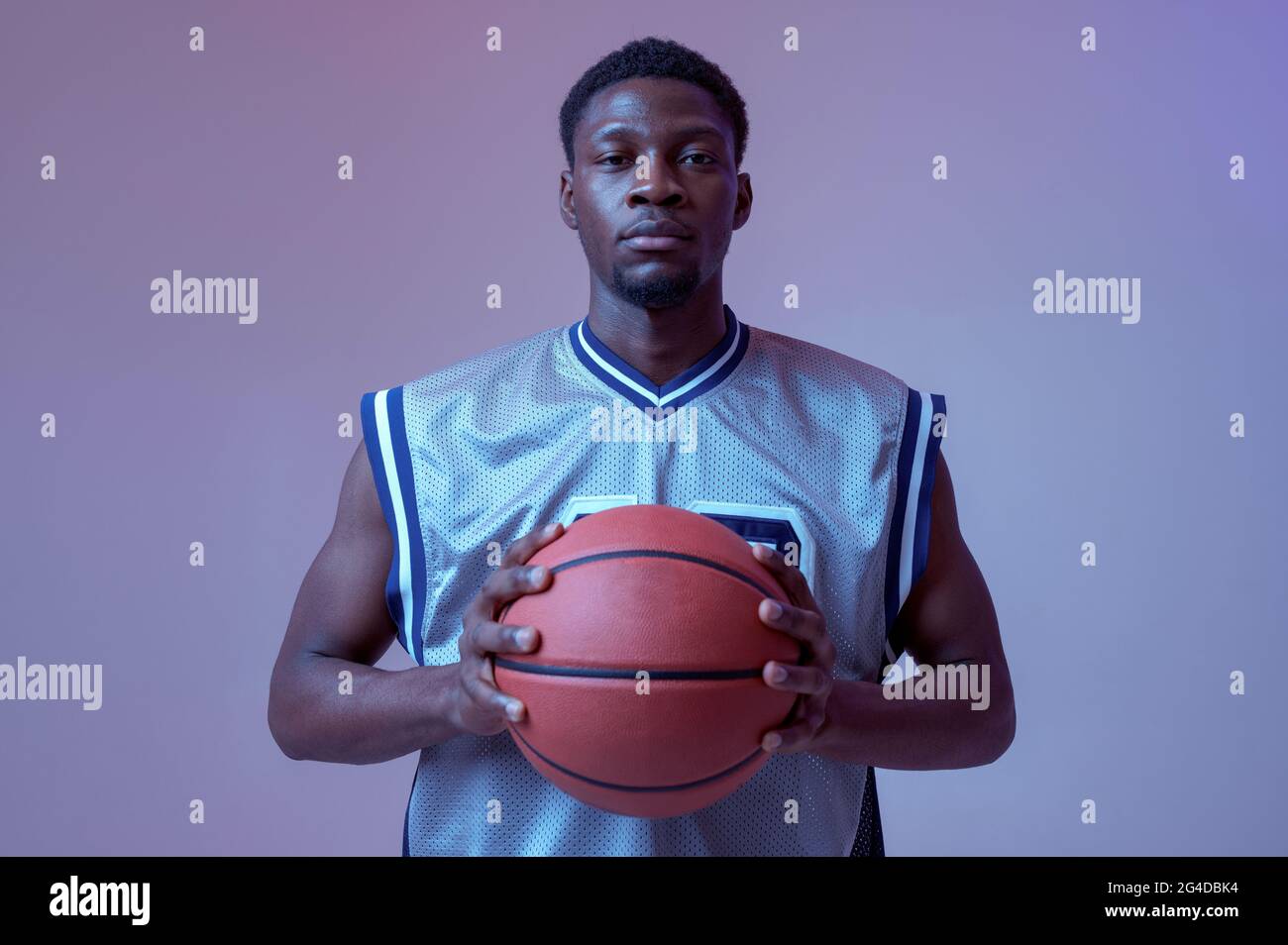 Confident basketball player poses with ball Stock Photo - Alamy