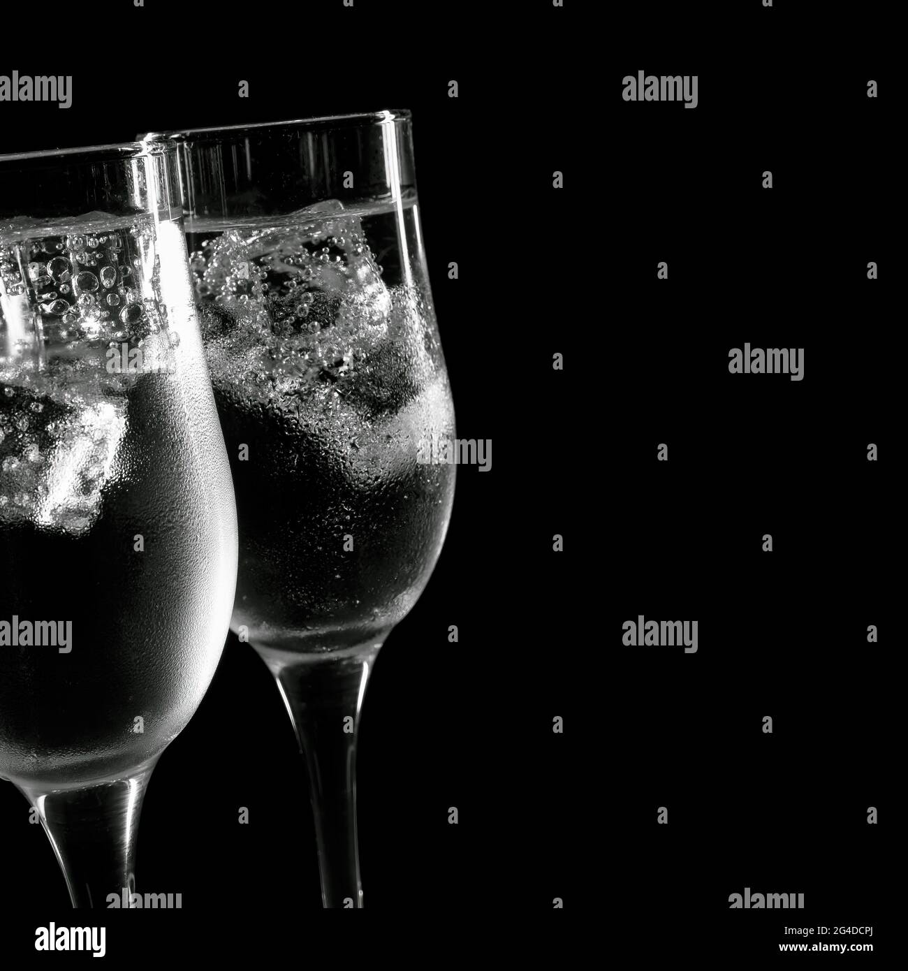 A refreshing, cold drink in glasses with ice on a black background ...