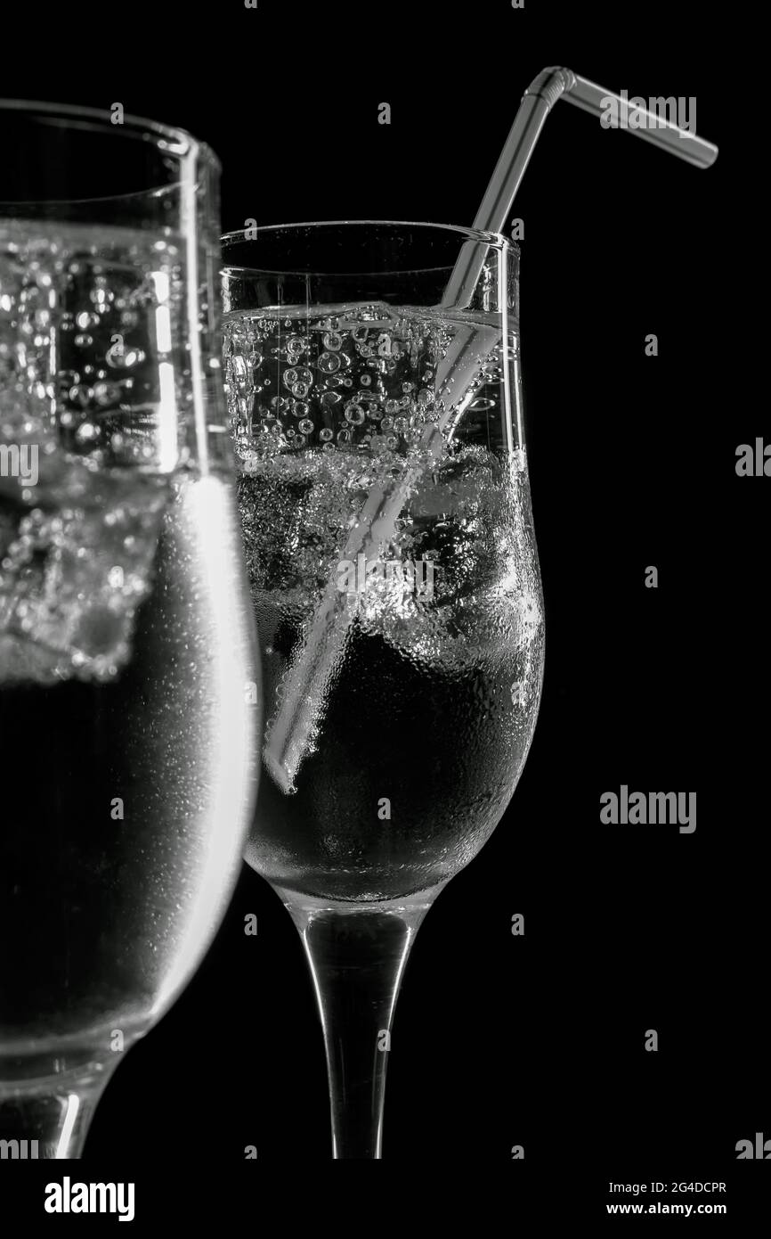 A refreshing, cold drink in glasses with ice on a black background ...