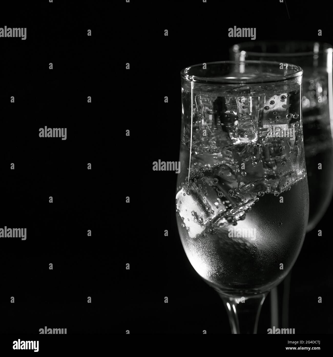 A refreshing, cold drink in glasses with ice on a black background ...
