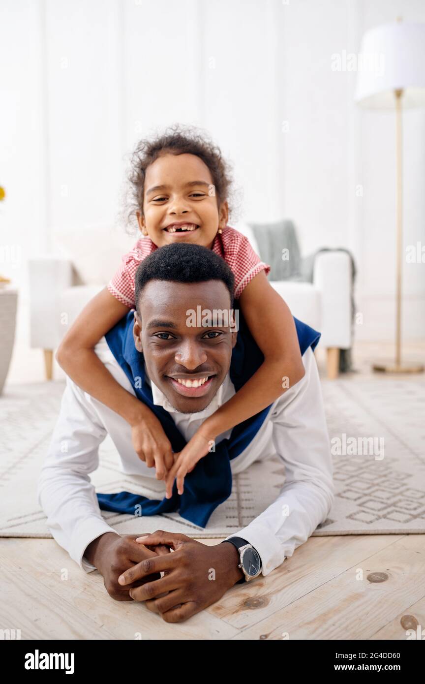 Smiling father and little daughter in living room Stock Photo - Alamy