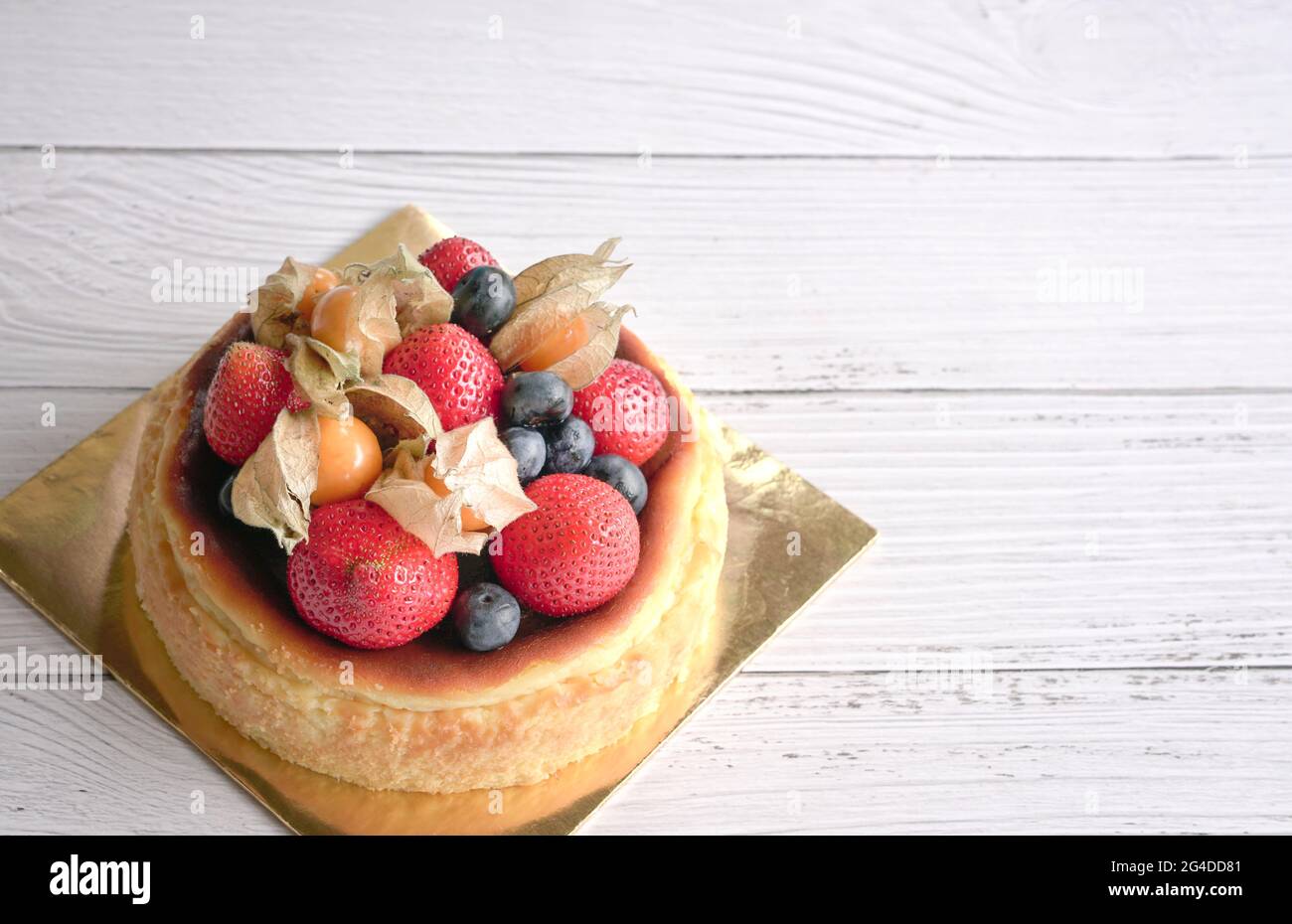 Burnt Cheese Cake decorated with fruit strawberries and blueberries ...