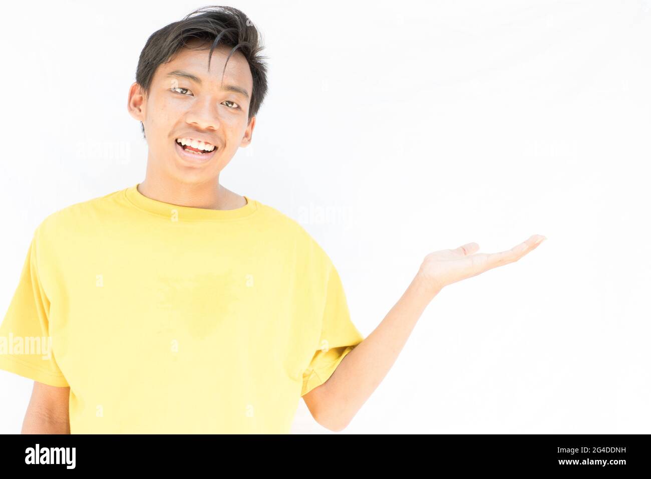 Happy Indonesian guy standing with each hand on the right side as if ...