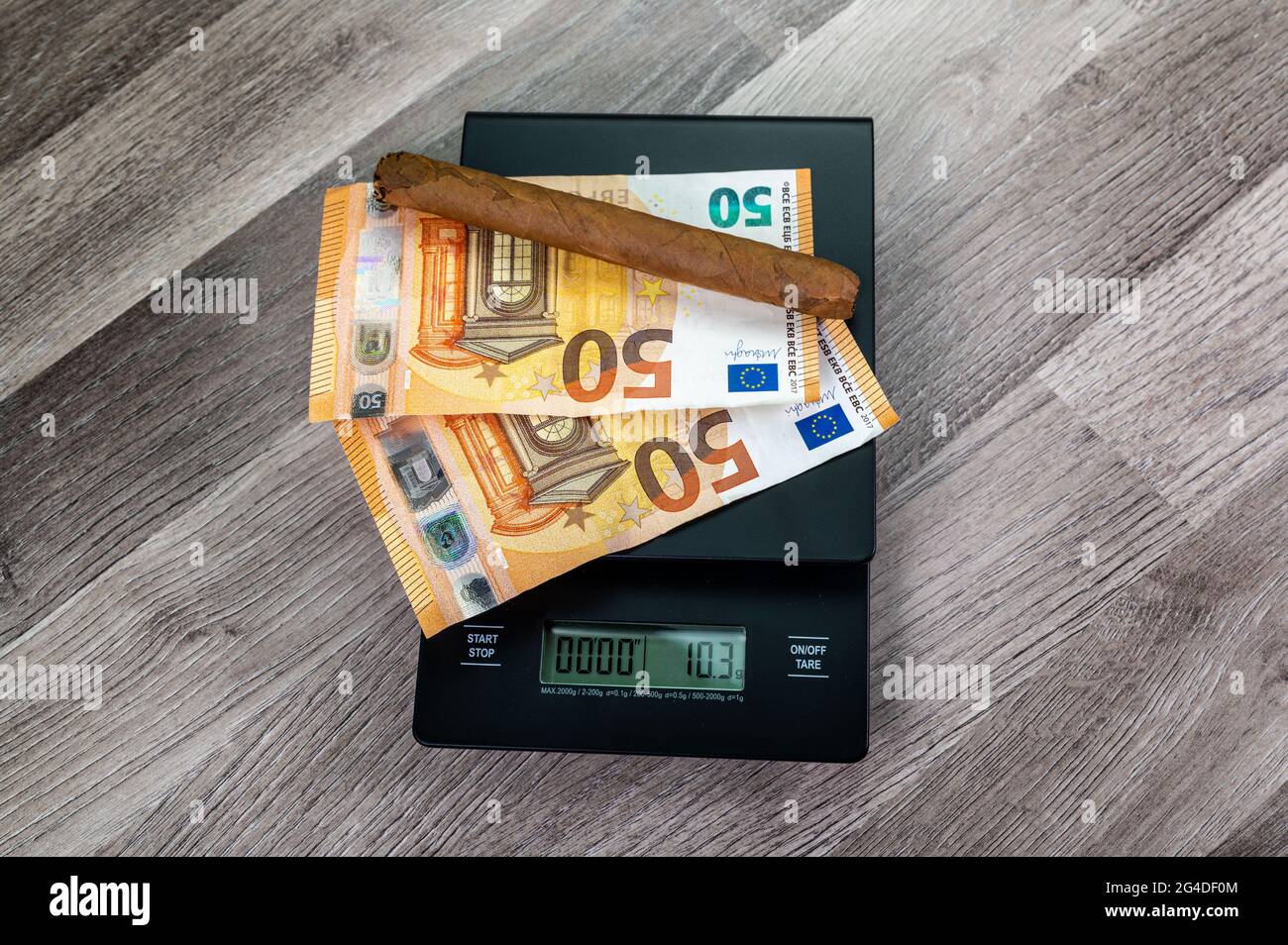 euro banknotes on top of a scale with cigar on a wooden table Stock ...