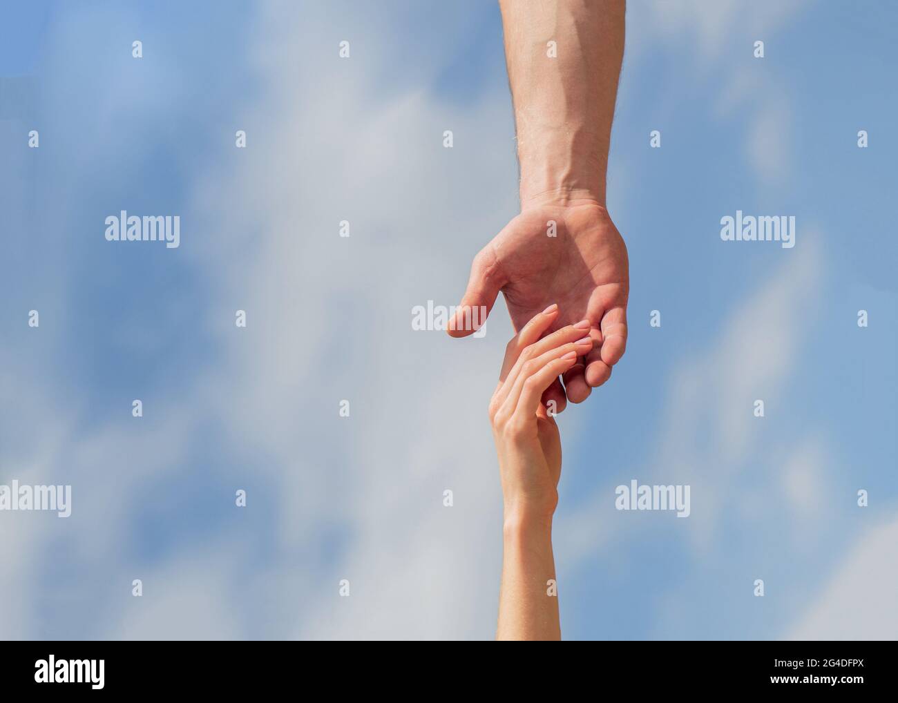 Giving a helping hand. Hands of man and woman on blue sky background ...