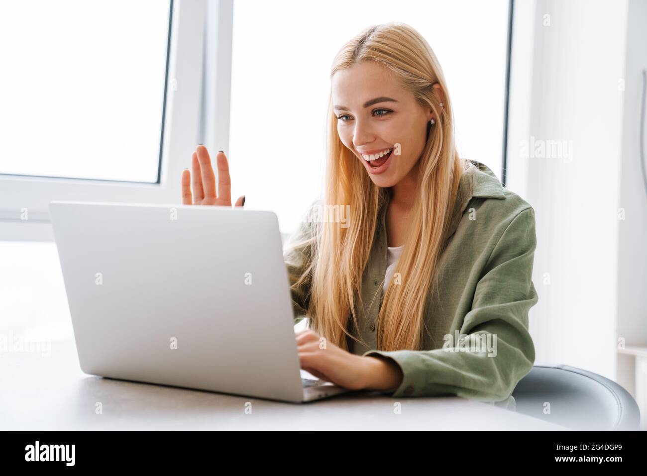Happy smiling young woman with laptop computer having video call at ...