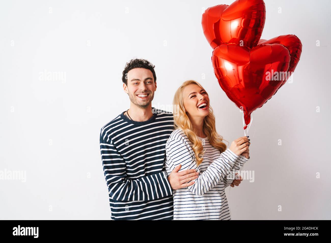 Happy romantic couple laughing while posing with heart balloons ...