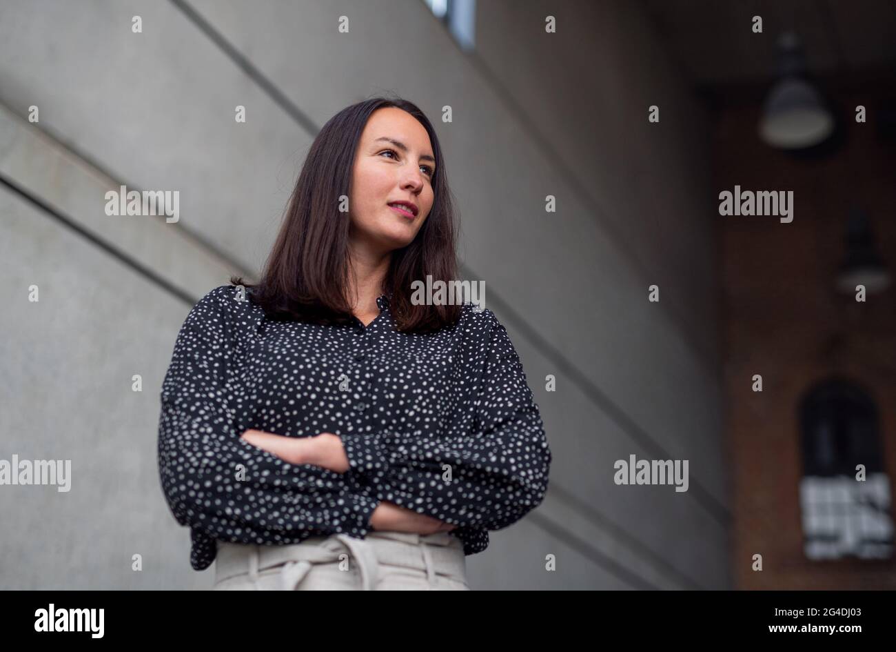 Low-angle view portrait of mid adult businesswoman standing indoors ...