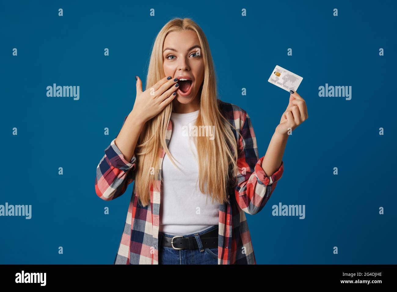 Blonde surprised woman exclaiming while showing credit card isolated ...