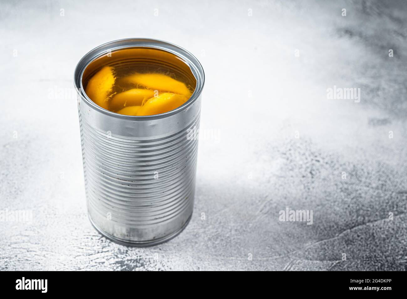 Canned mango slices in syrup in a metal can. White background. Top view ...