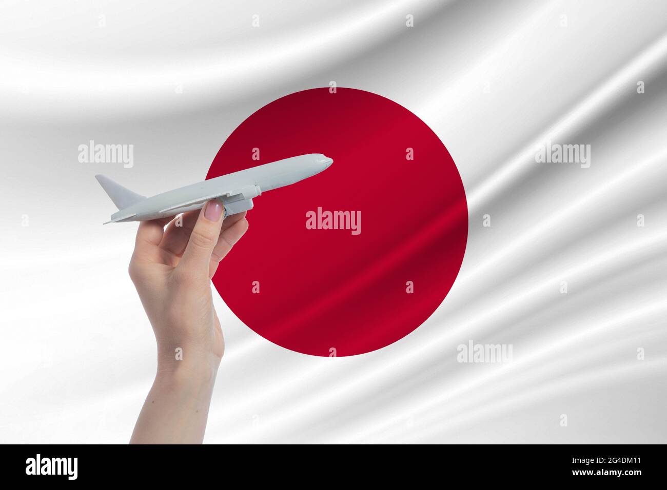 Airplane in hand with national flag of Japan Travel to Japan Stock ...