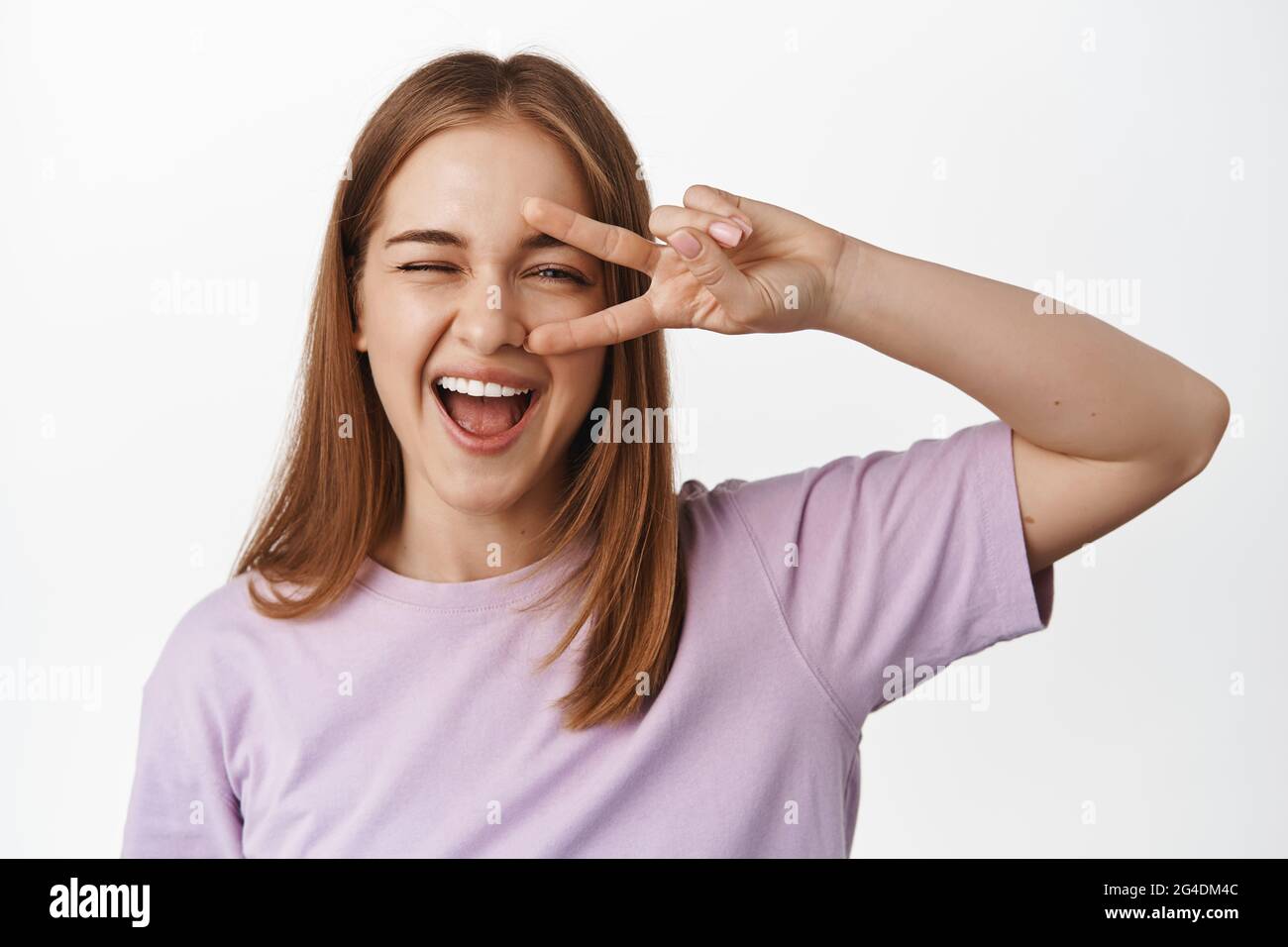 Smiling woman with v sign winking hi-res stock photography and images ...