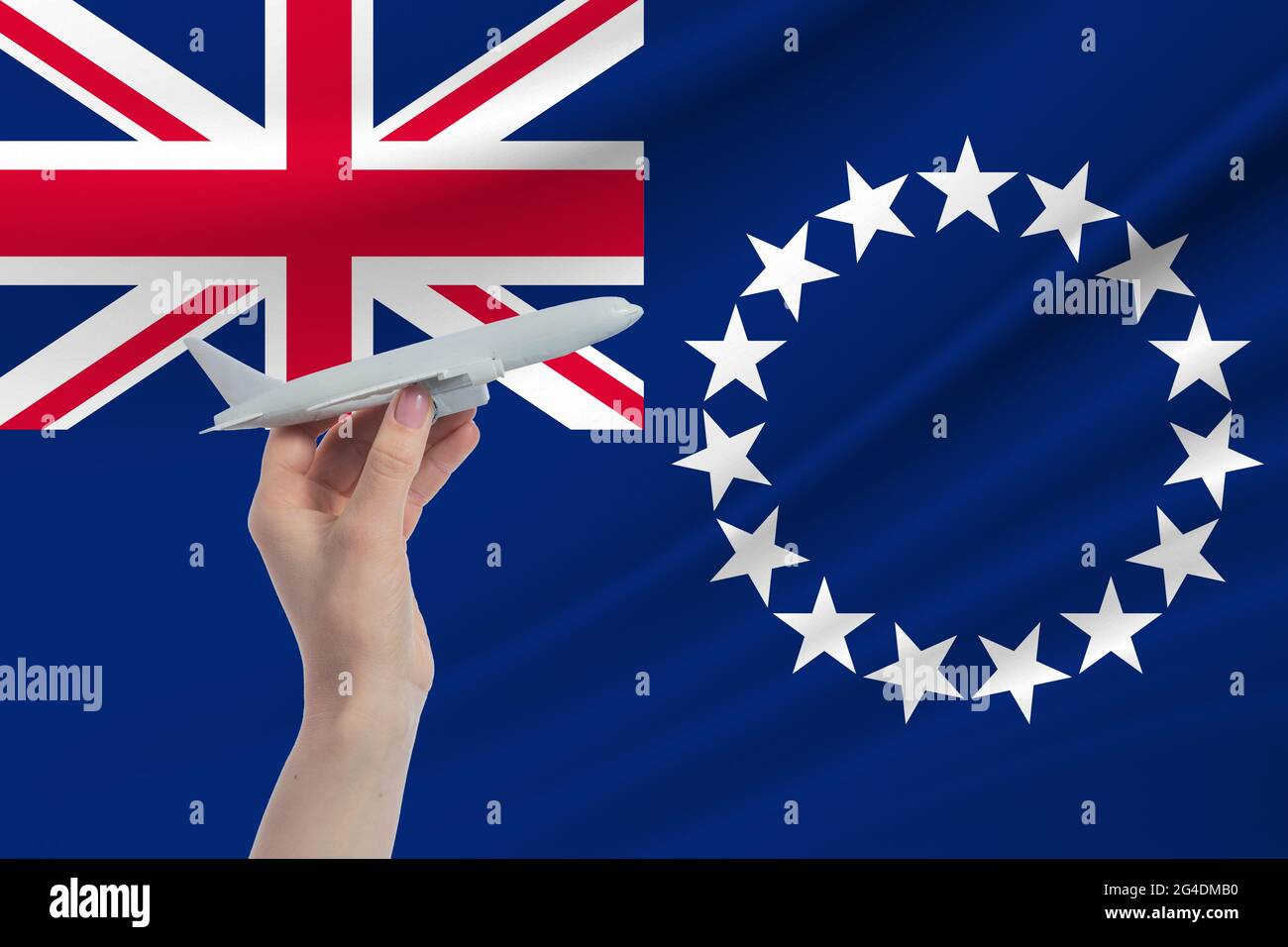 Airplane in hand with national flag of Cook Islands. Travel to Cook ...