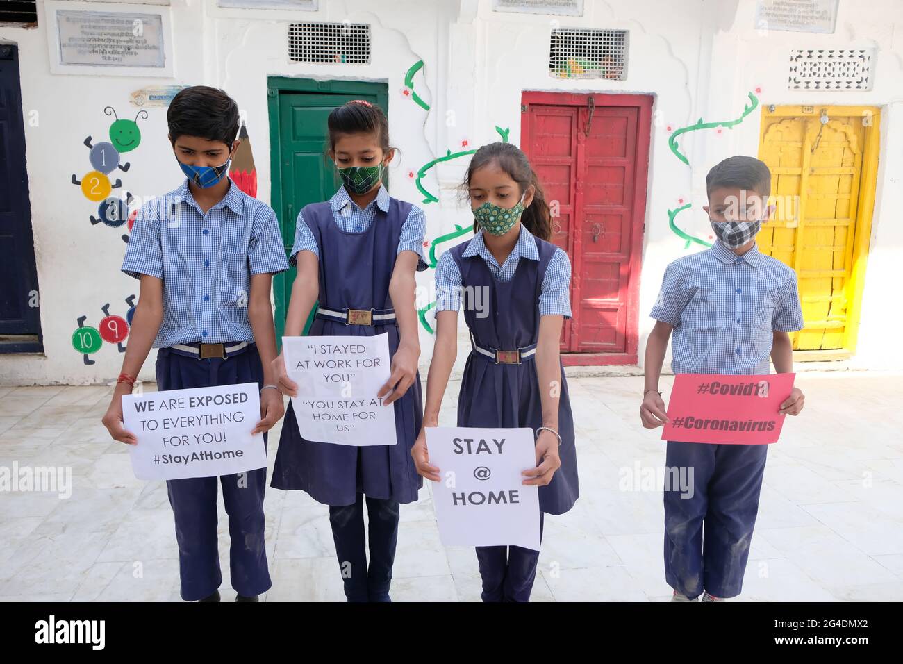 Group of Indian children in face masks and school uniforms holding ...