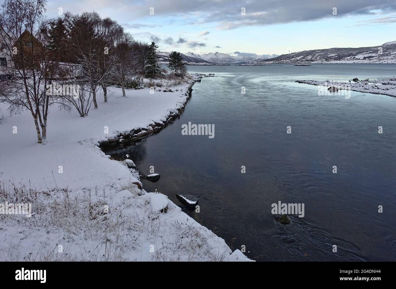 Beautiful winter landscape with a sea under a cloudy sky in Norway ...