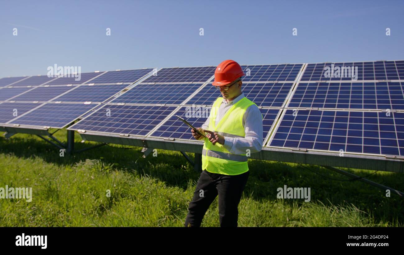 Engineer working use tablet near solar batteries construction renewable ...
