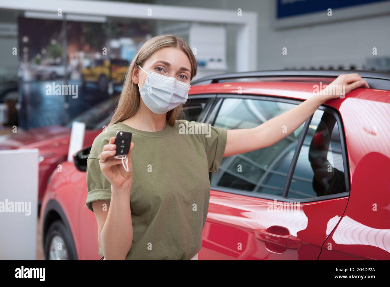Woman wearing medical face mask while buying new auto at car dealership ...