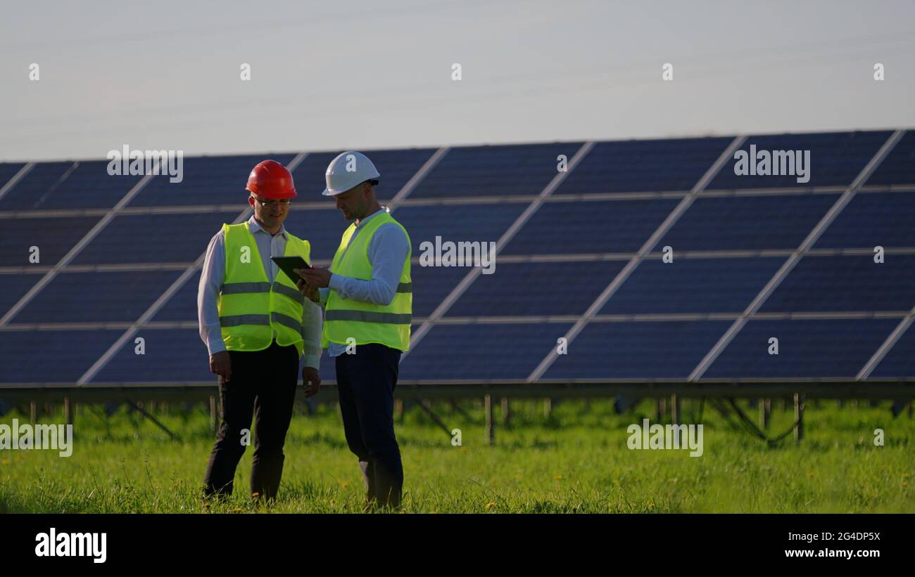 The engineer is greeting his colleagues. They are talking and standing ...