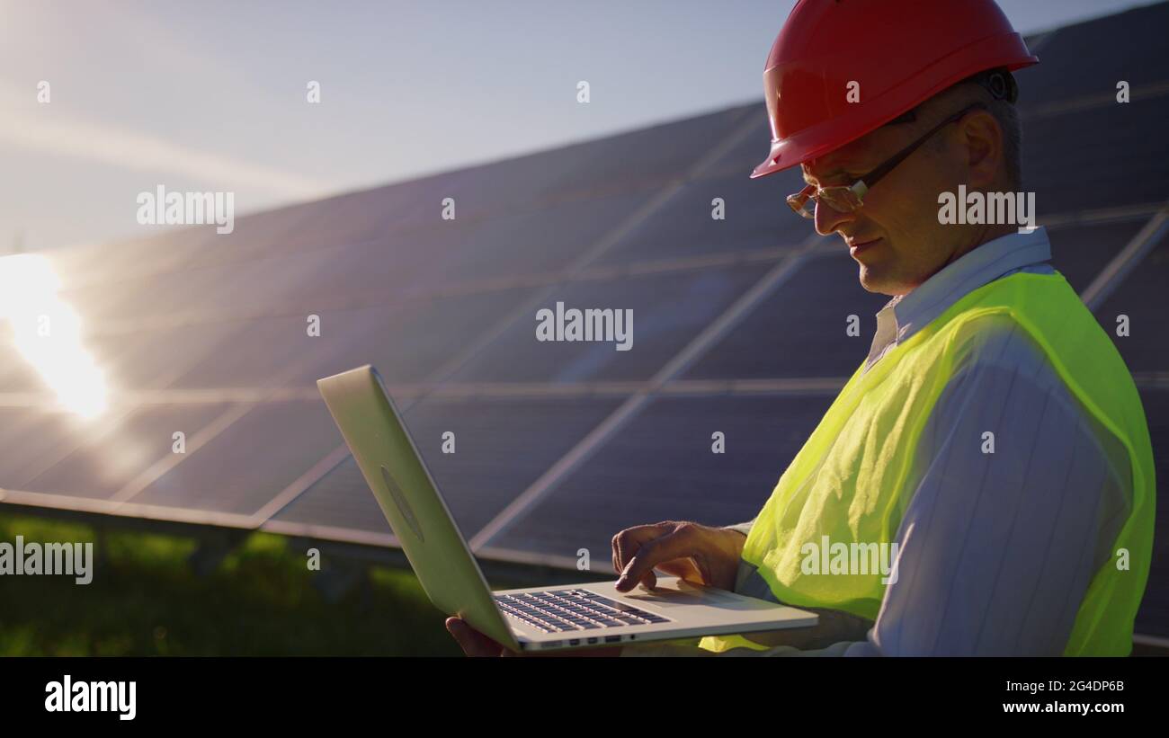 Engineer working use laptop stand near solar batteries construction ...