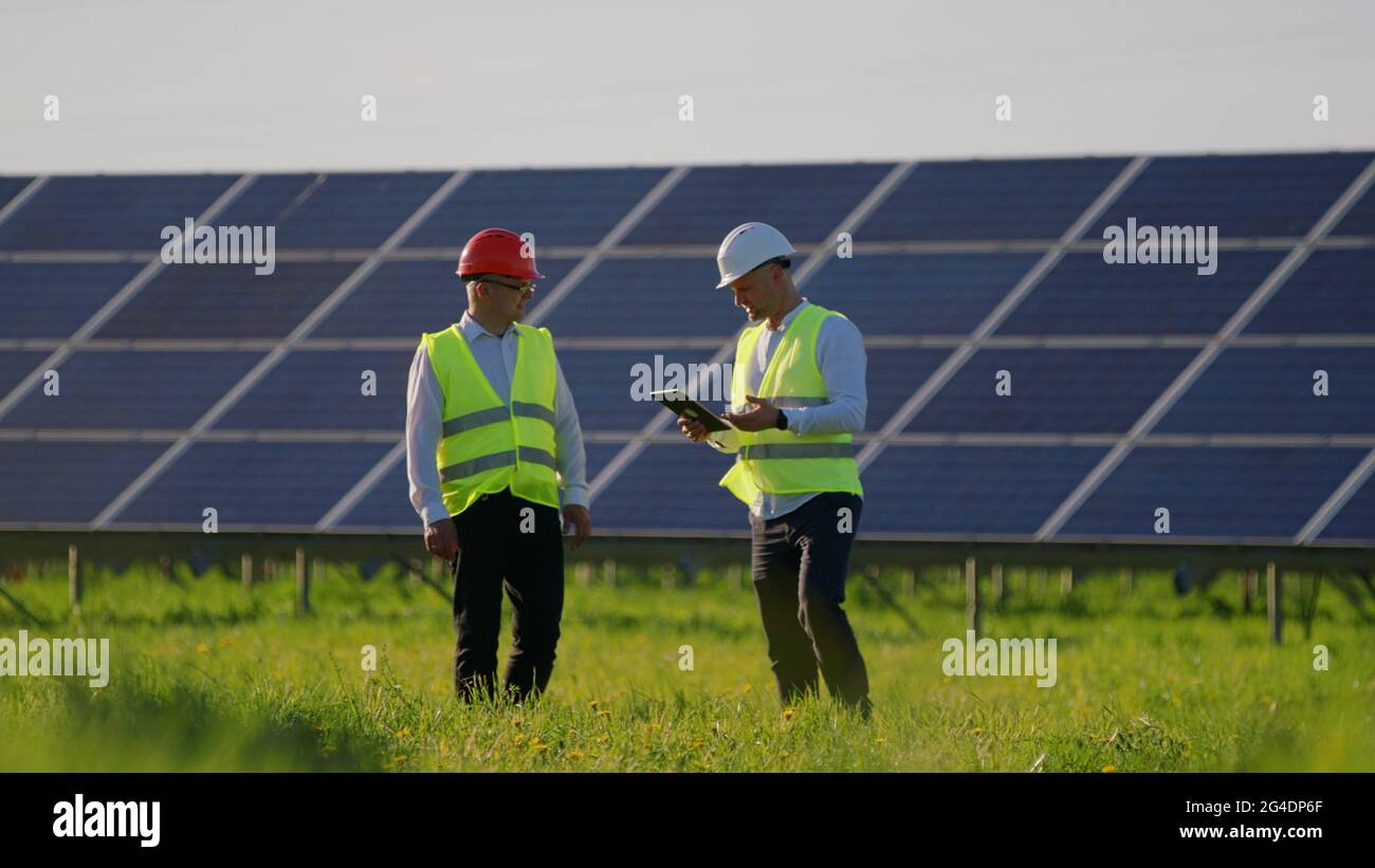 The engineer is greeting his colleagues. They are talking and standing ...