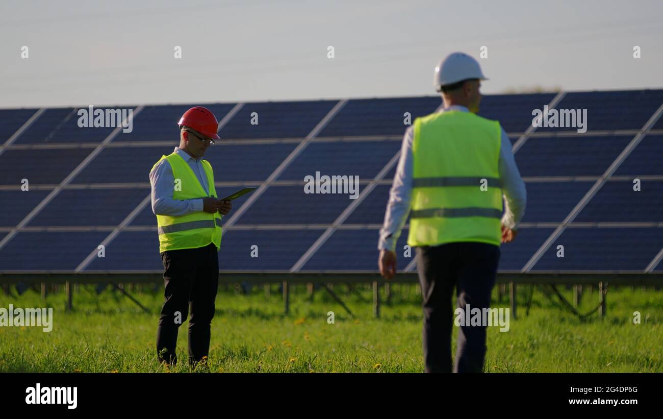 The engineer is greeting his colleagues. They are talking and standing ...