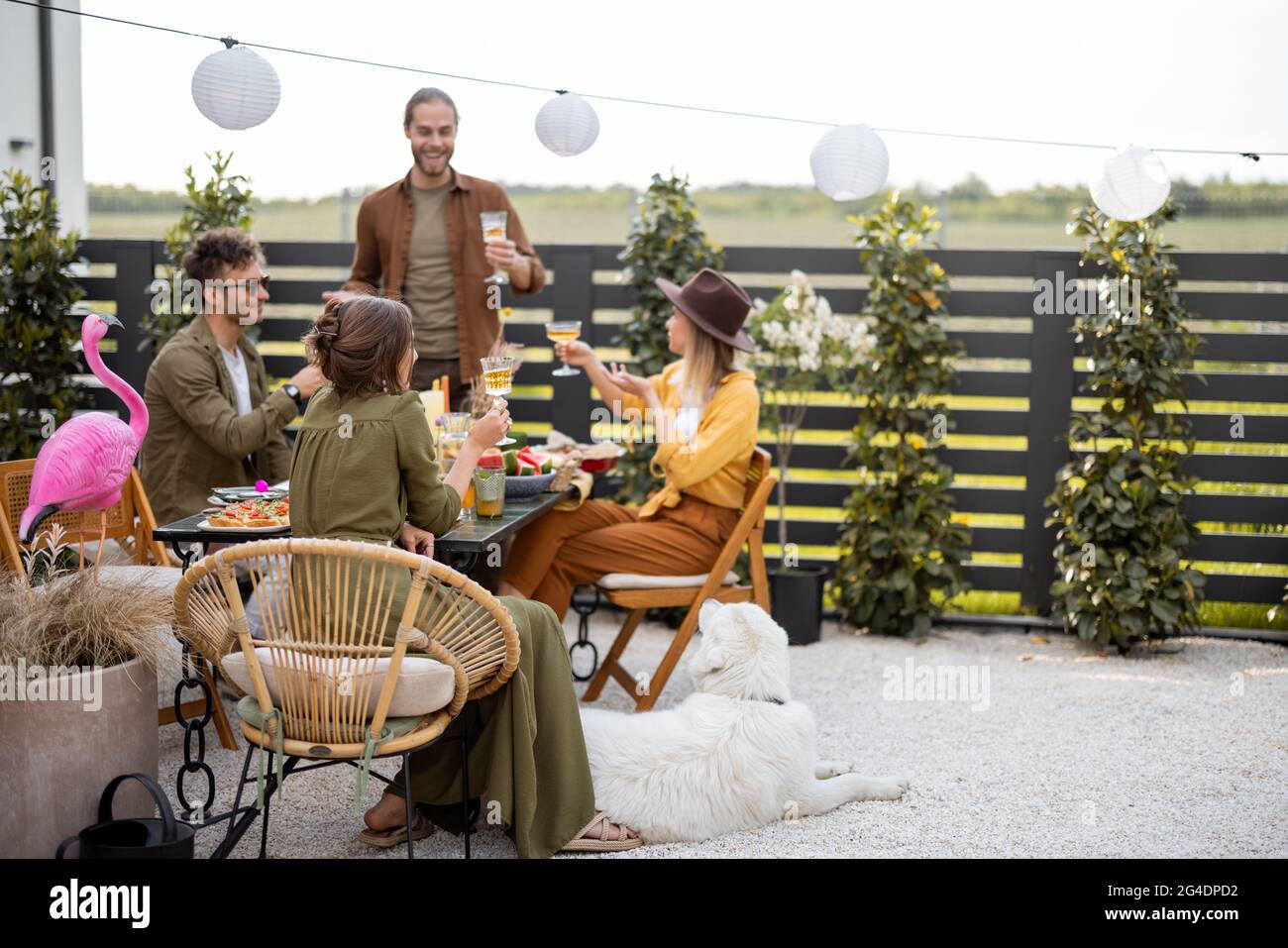 A group of young friends have delicious dinner, toasting and having ...