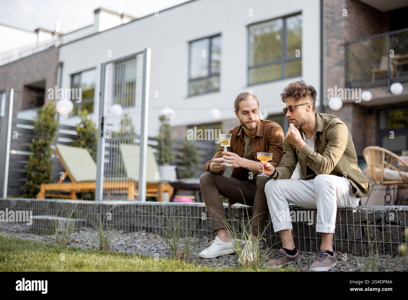 Two male friends talking on a porch of the country house Stock Photo ...