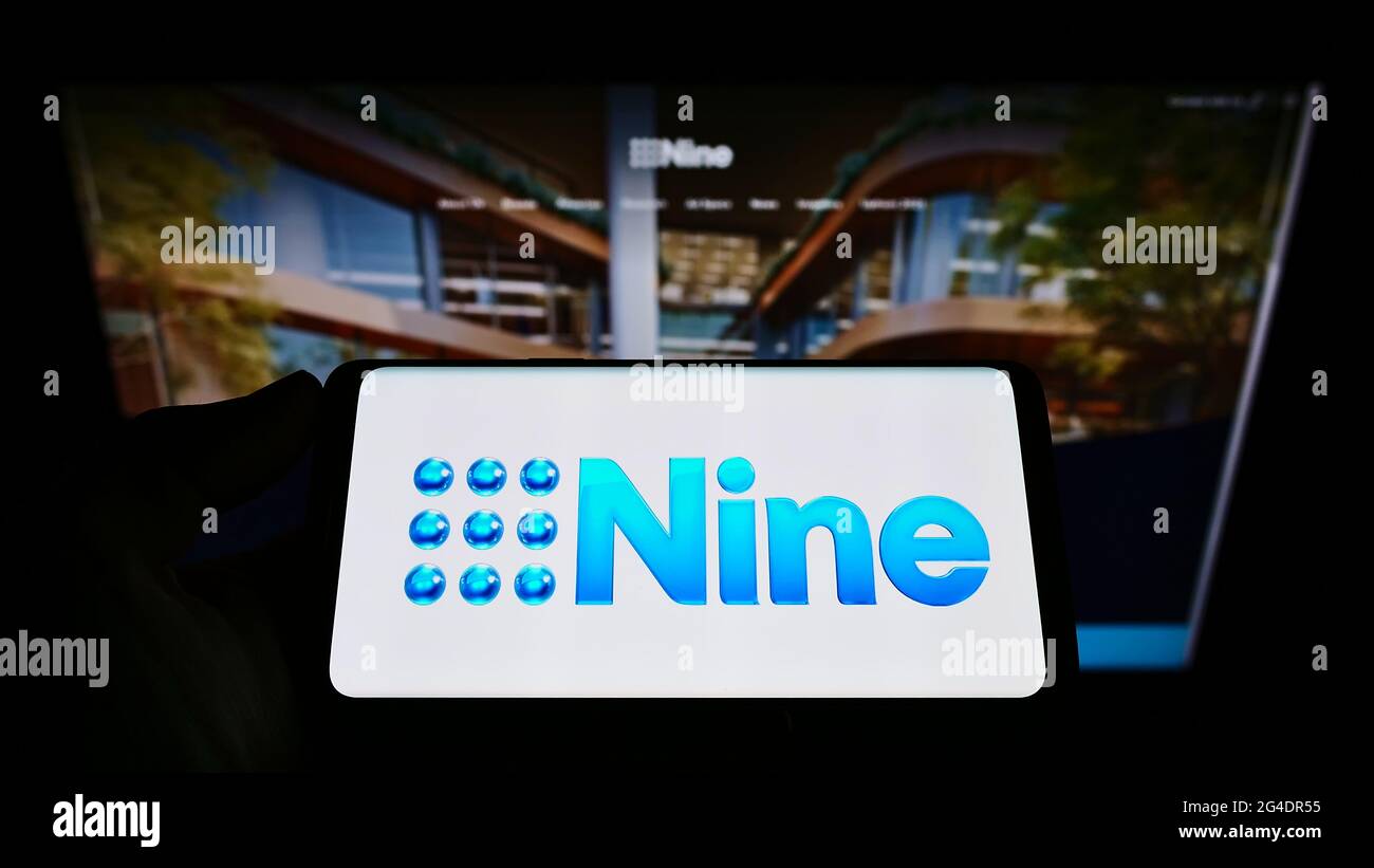 Person holding smartphone with logo of Australian Nine Entertainment Co ...