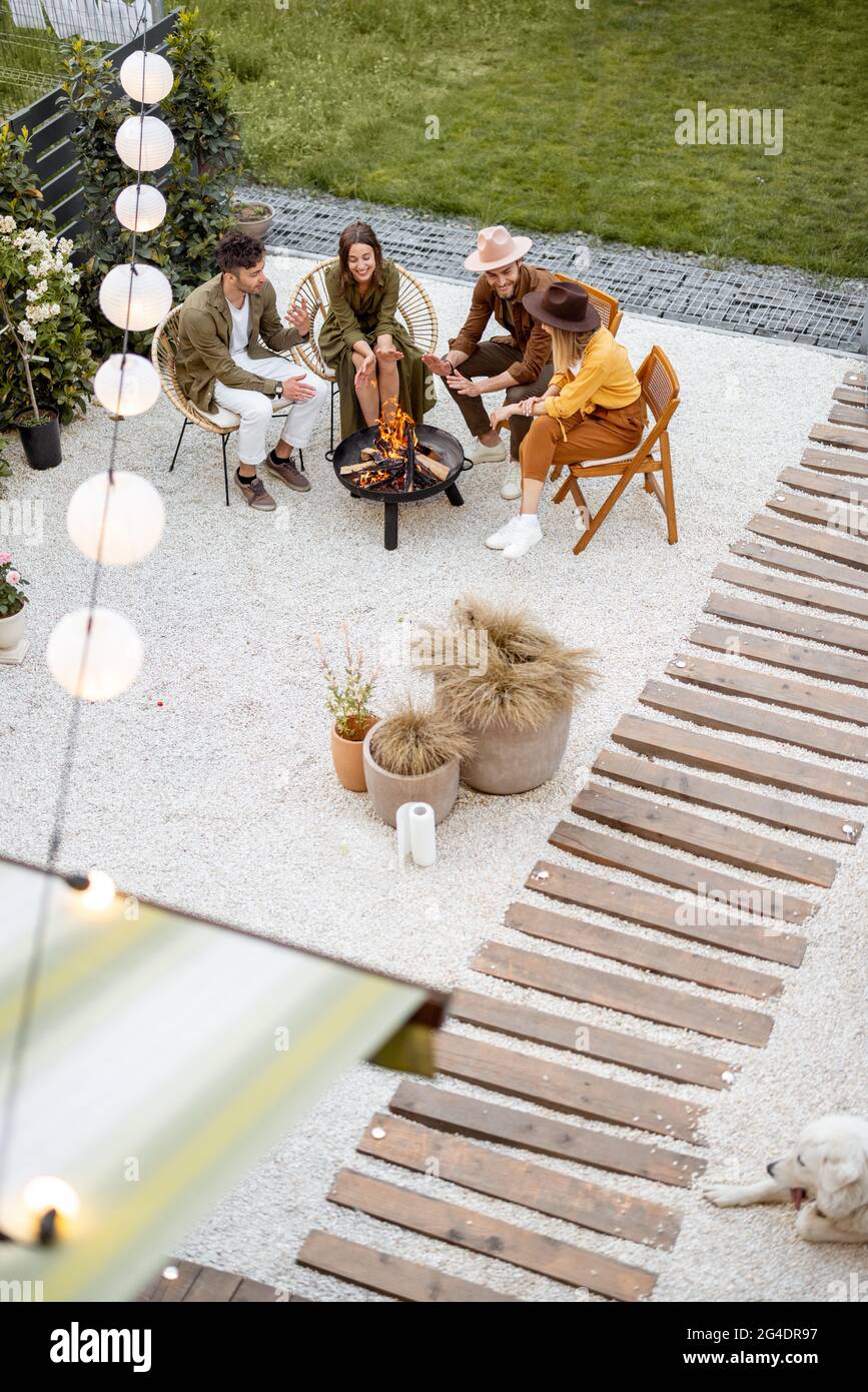 Top view on a beautiful backyard with people sitting by a fireplace ...
