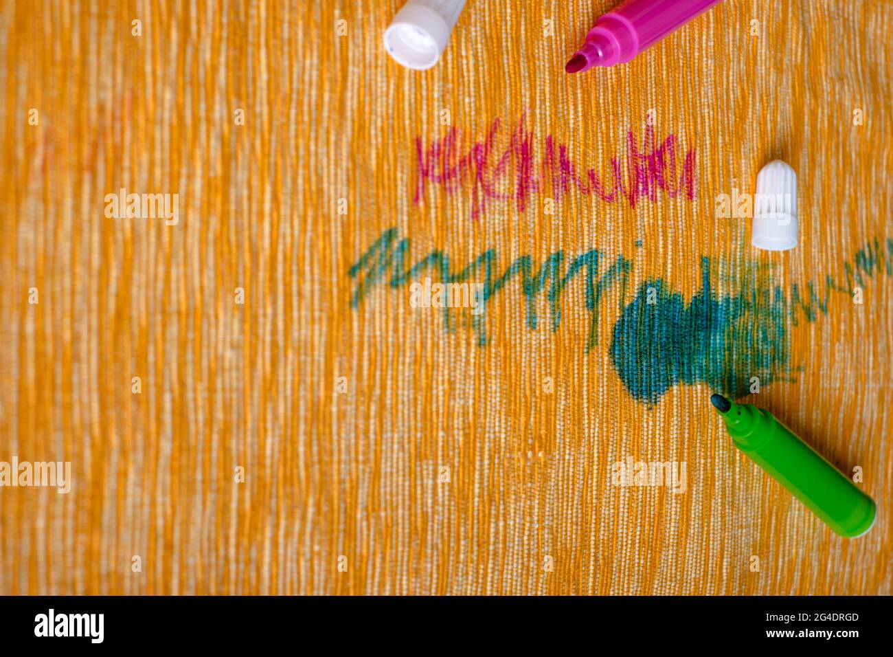 Dirty stains of felt-tip pens on the yellow upholstery of the sofa. top ...