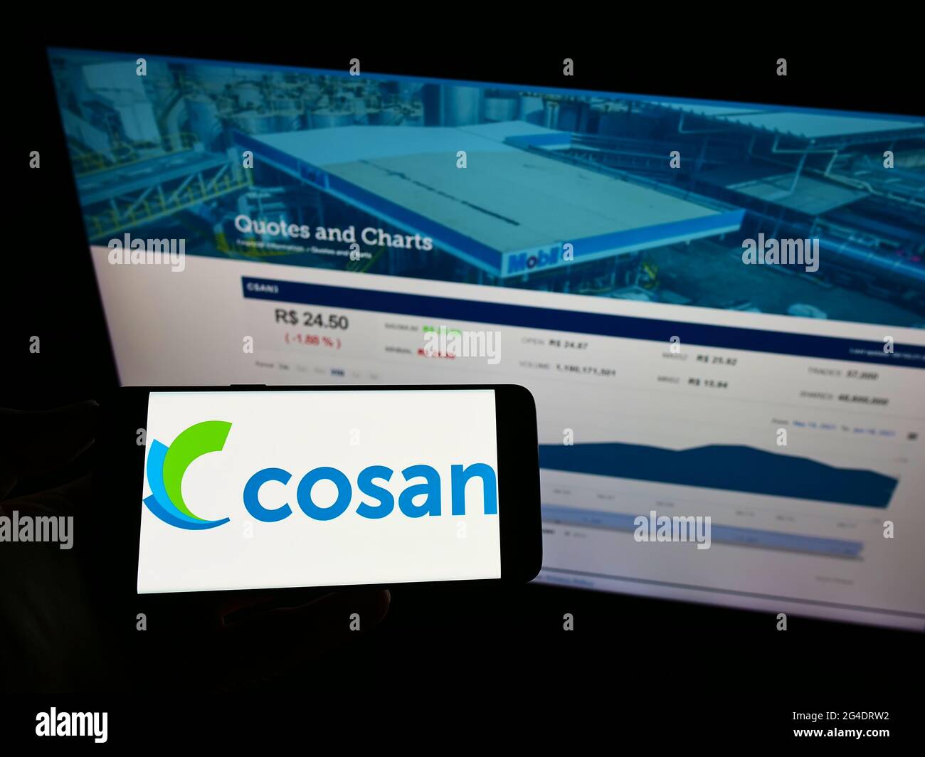 Person holding smartphone with logo of Brazilian conglomerate Cosan S.A ...