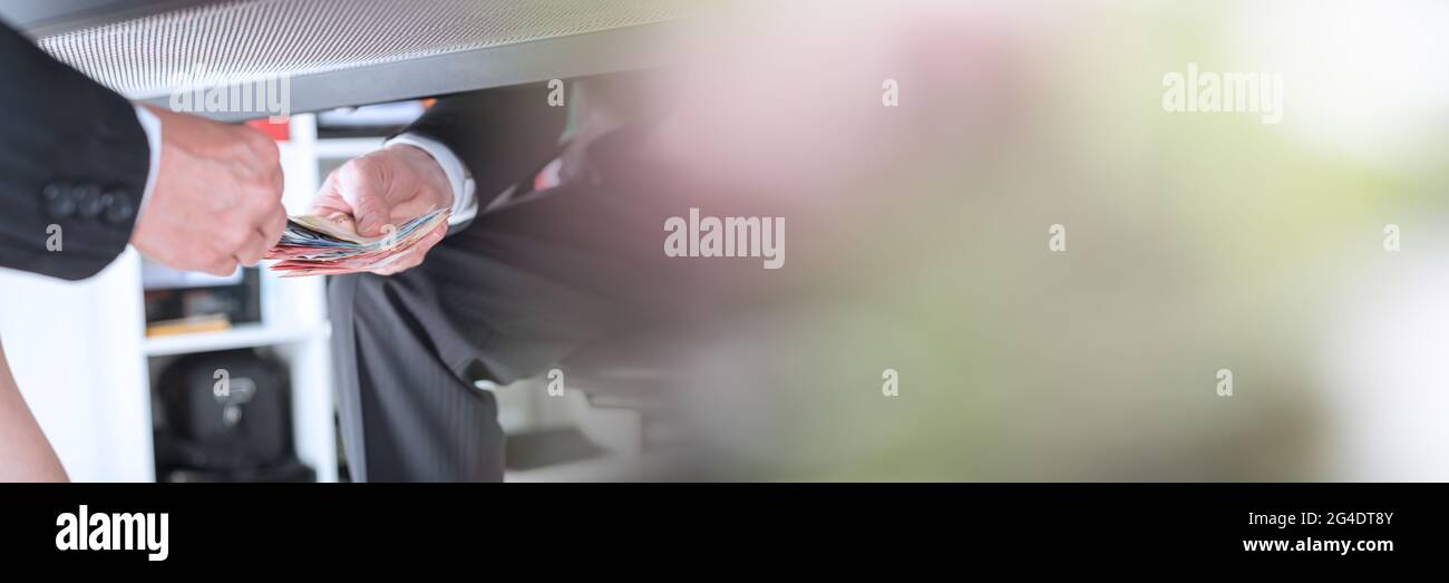 Businessman giving money under a table; panoramic banner Stock Photo ...