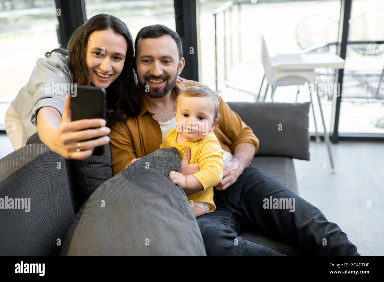 Happy family with a one year baby having a video call on phone Stock ...