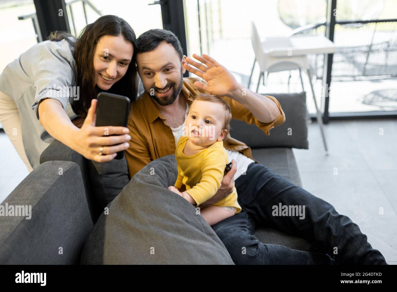 Happy family with a one year baby having a video call on phone Stock ...