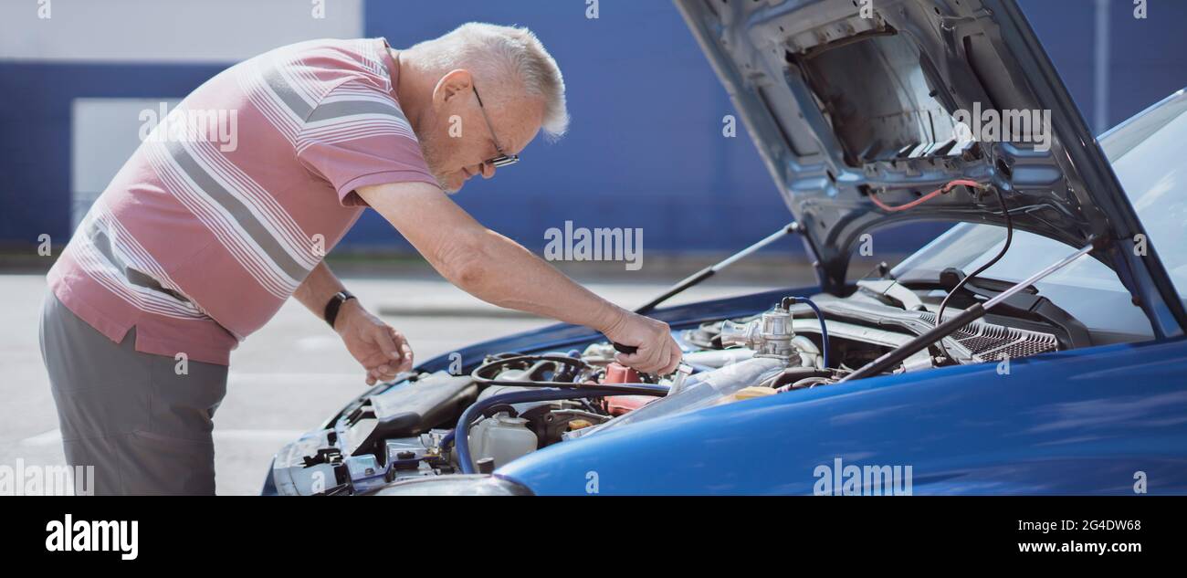 hobby of the senior man, old person fixing the car engine outdoors ...