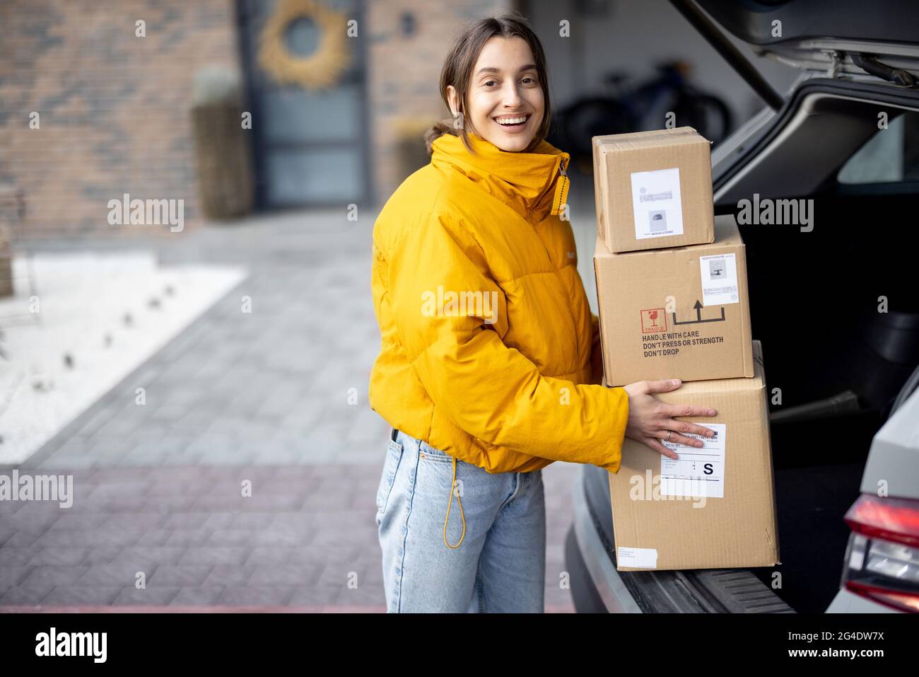 Woman arrives home with parcels Stock Photo - Alamy