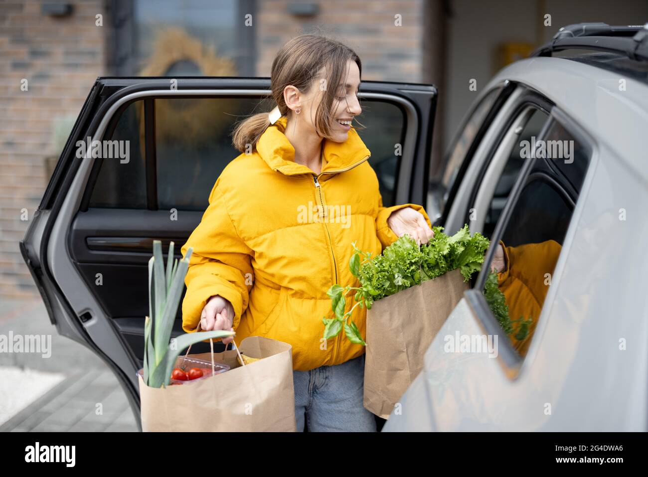 Woman arrives home with a groceries Stock Photo - Alamy