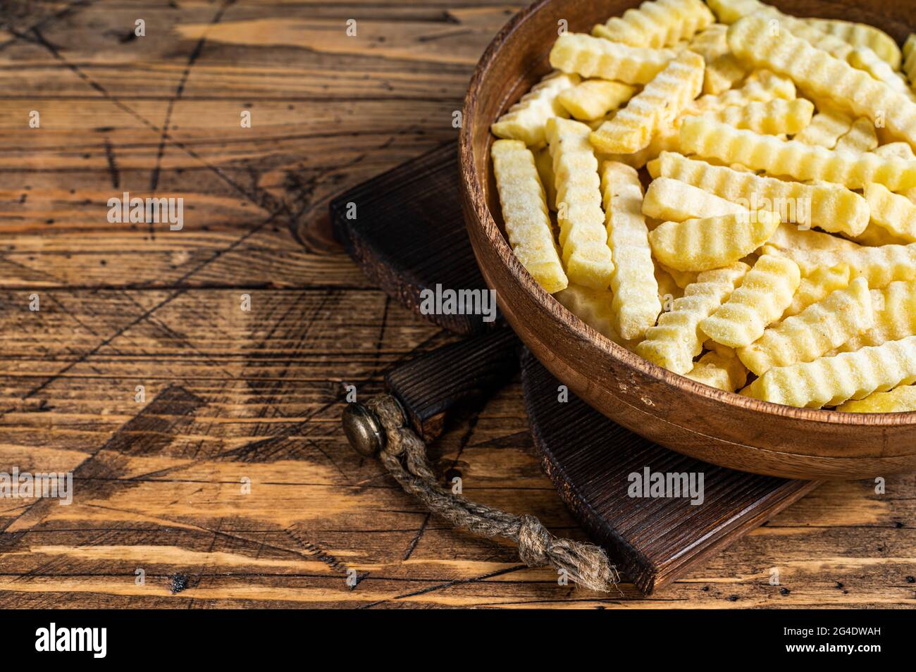 Frozen Crinkle oven French fries potatoes sticks in a wooden plate ...