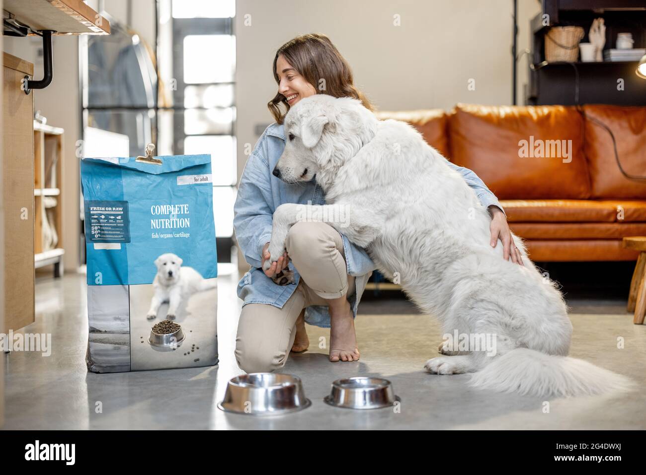 Woman feeding dog with a dry food at home Stock Photo - Alamy