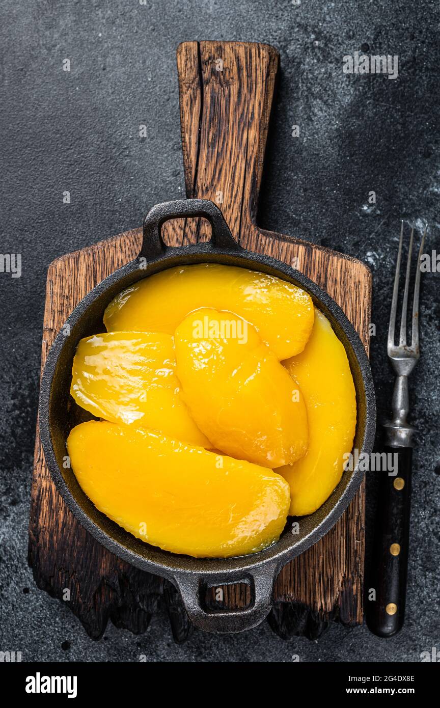 Canned mango slices in bowl. Black background. Top view Stock Photo - Alamy
