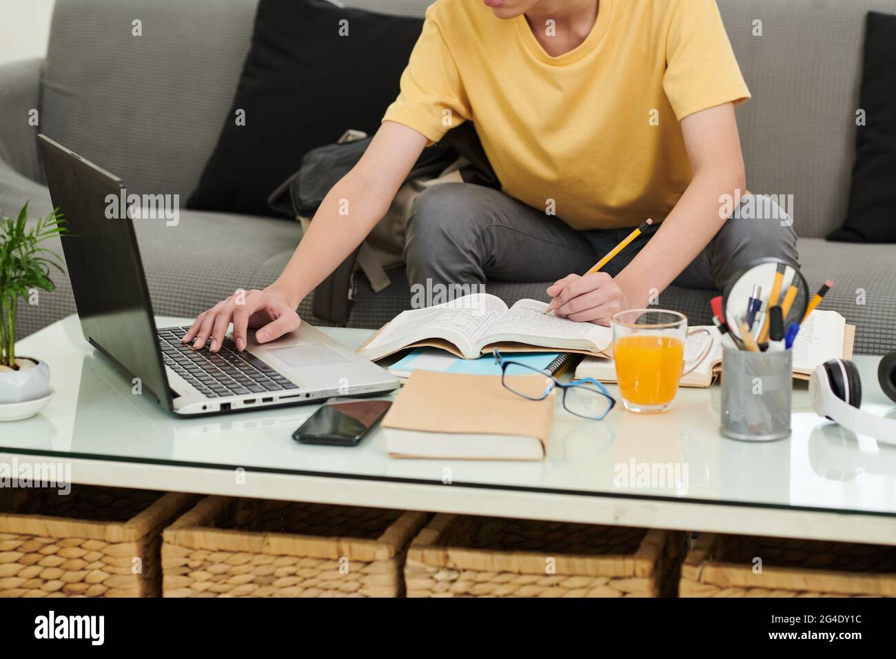 Cropped image of schoolboy doing homework at home, he is checking ...