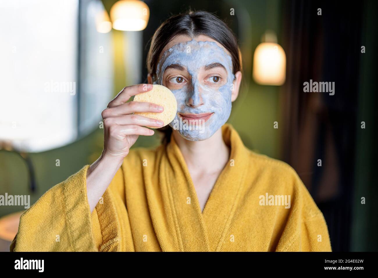 Woman removing cleansing mask from her face Stock Photo - Alamy