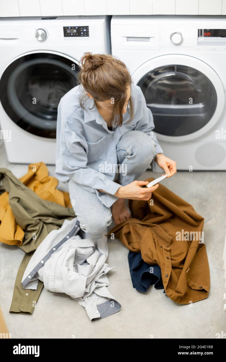 Housewife sorts dirty clothes in the laundry Stock Photo - Alamy