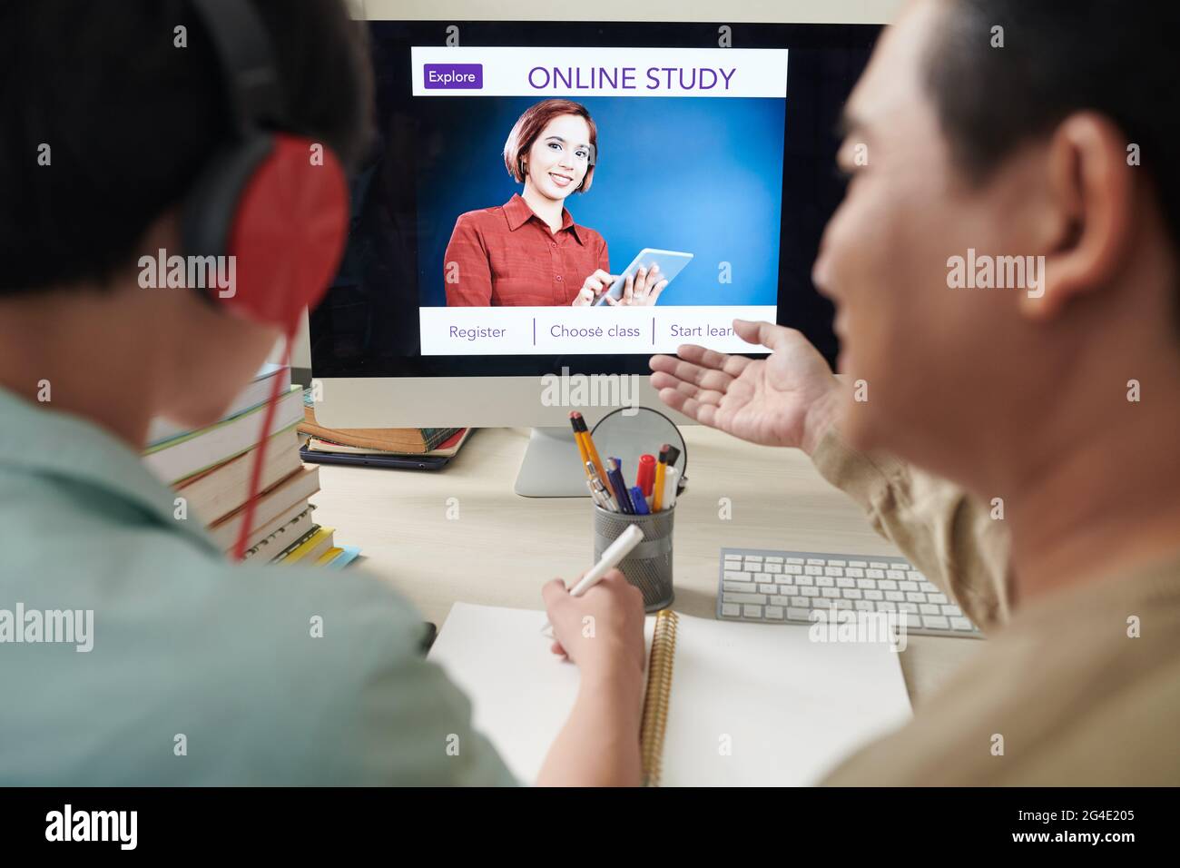 Father helping son to install application for online studying on ...